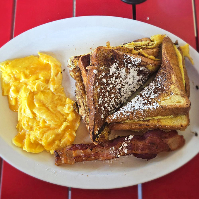 French toast dusted with powdered sugar alongside bacon and eggs—breakfast done right, no apologies needed for the carbs here.