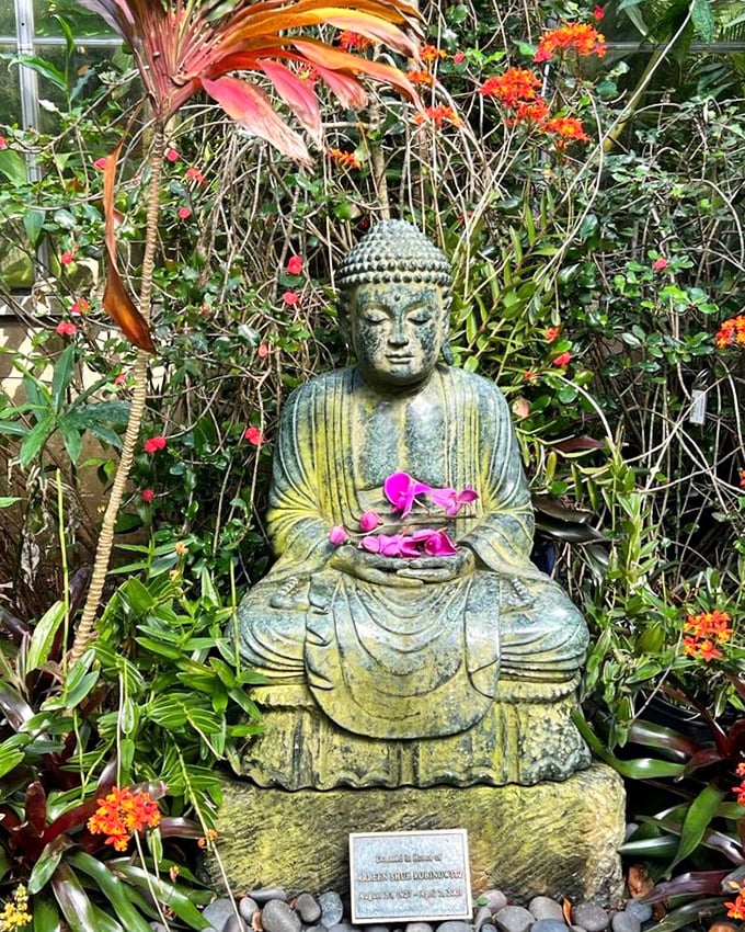 This peaceful Buddha, adorned with orchid offerings, reminds visitors to stop and breathe &ndash; something we could all use more of.