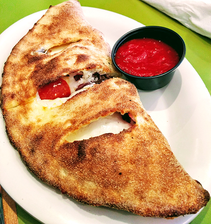 The calzone: pizza's mysterious, folded cousin who keeps all the good stuff hidden inside until that first, steam-releasing bite.