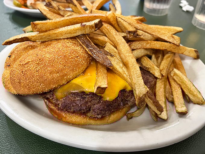 A burger that requires both hands and a strategy. Those hand-cut fries aren't just sides &ndash; they're co-stars in this lunchtime drama.