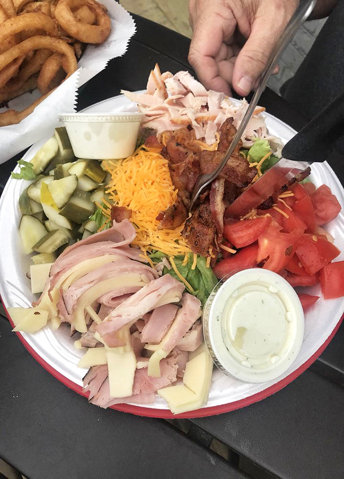 This chef salad comes loaded with more toppings than a pizza convention, because apparently someone decided salads deserved equal architectural ambition.