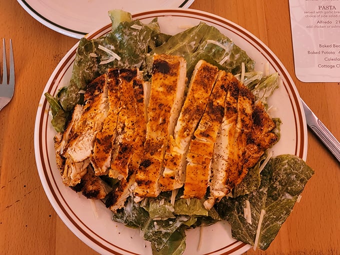 Grilled chicken perched atop crisp romaine like it's the throne it deserves, with each bite offering the perfect Caesar salad ratio that took centuries to perfect. 