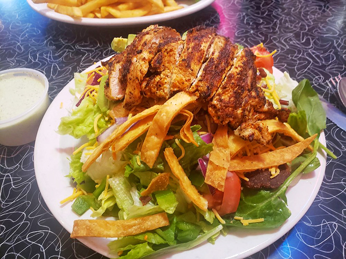 This chicken salad isn't playing around&mdash;seasoned, grilled, and perched atop fresh greens with crispy tortilla strips for that perfect crunch.
