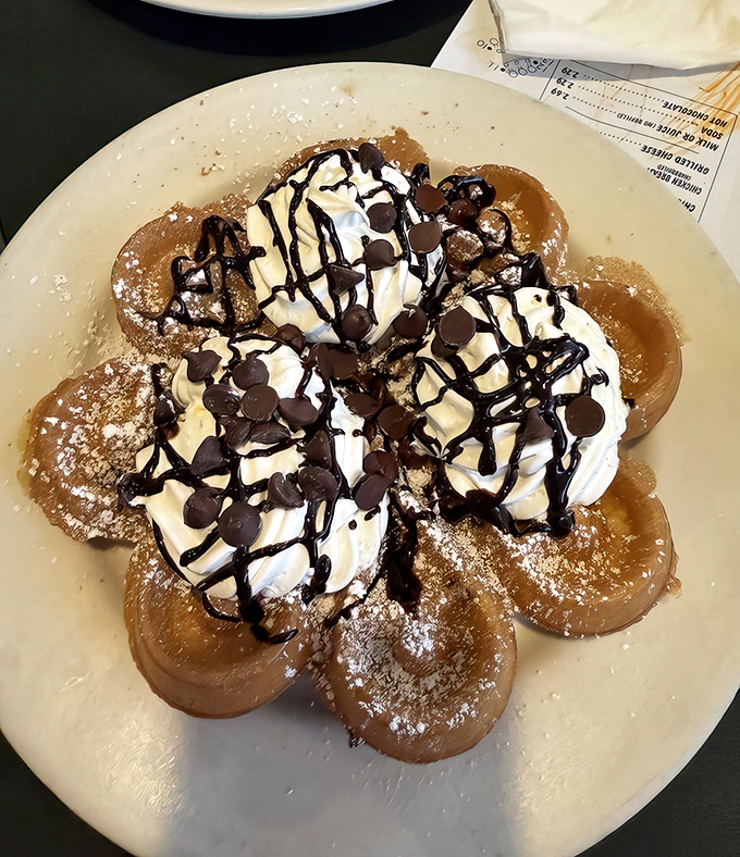 Chocolate chip waffles crowned with whipped cream mountains and chocolate drizzle. Dessert masquerading as breakfast, and nobody's complaining.