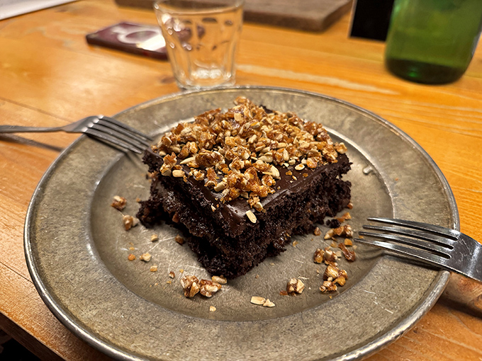 This isn't just chocolate cake; it's a dark, mysterious square of happiness topped with crunchy bits that demand a moment of respectful silence.