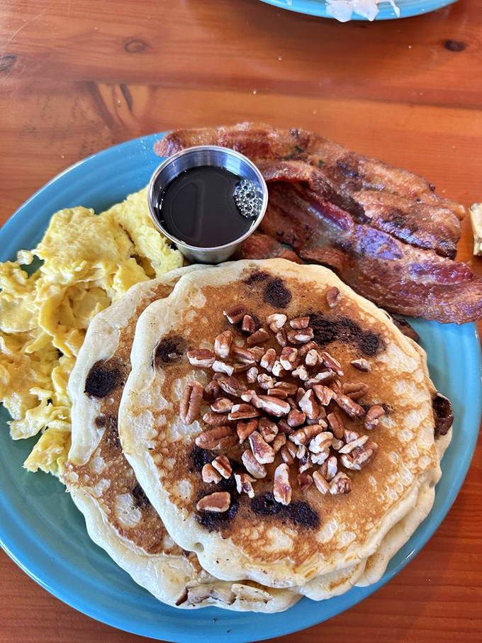Pancakes with personality&mdash;golden discs topped with pecans and ready for maple syrup baptism. Even the bacon looks impressed.