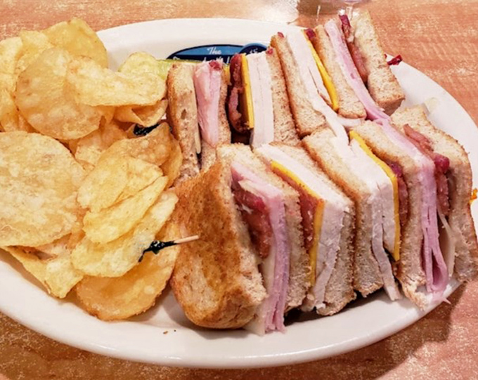 A club sandwich that towers like a skyscraper of flavor. Those house-made chips aren't just a side&mdash;they're a statement.