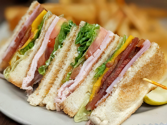 A club sandwich stacked higher than some Dallas skyscrapers, with layers of meat, cheese, and veggies that require jaw gymnastics to tackle properly.