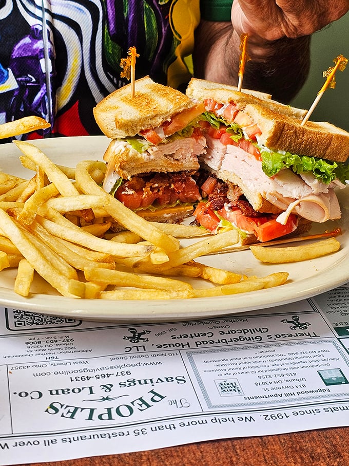 The club sandwich&mdash;America's three-story answer to lunch indecision. Turkey, bacon, and veggies stacked so high they need those little toothpick flags as structural support.