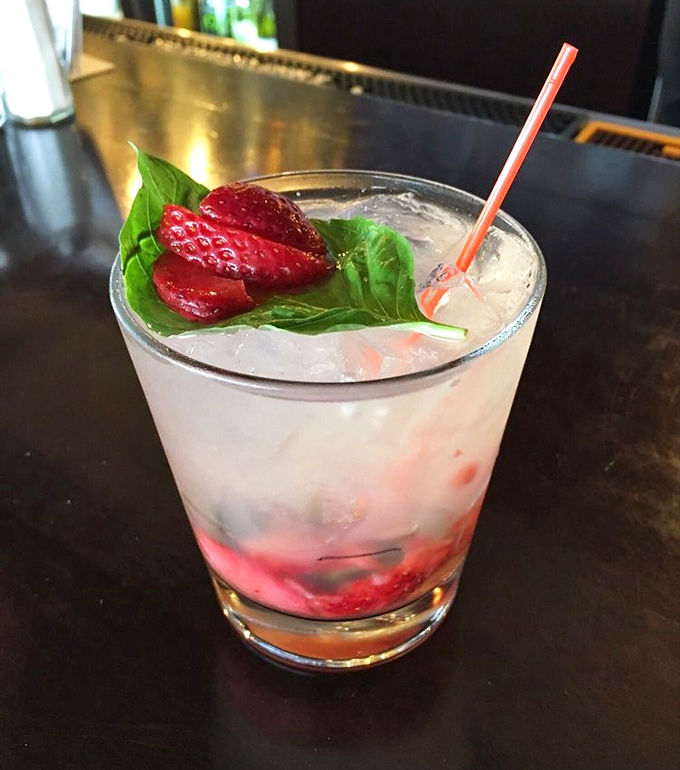 A cocktail that looks like Minnesota summer in a glass. That strawberry and basil garnish isn't just pretty &ndash; it's practically winking at you.