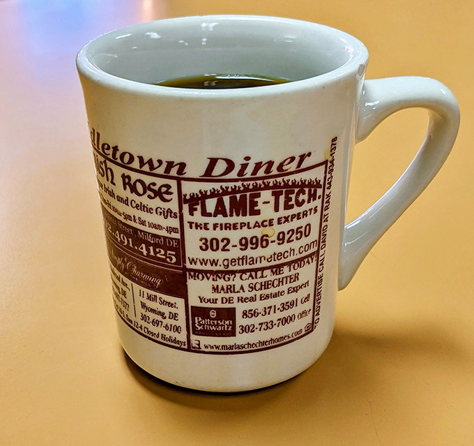 Coffee served in mugs that advertise local businesses - because community spirit tastes better than corporate branding.