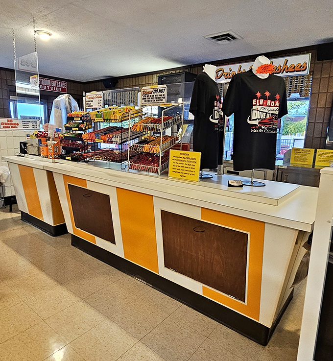 Candy, popcorn, and drive-in merchandise await at this delightfully retro concession counter. The orange panels scream "1970s" in the best way.
