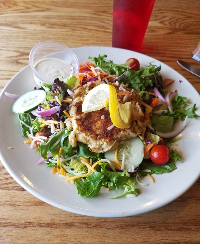 This isn't just any crab cake salad &ndash; it's a masterclass in balance, with a golden-brown patty perched atop a garden of fresh vegetables.