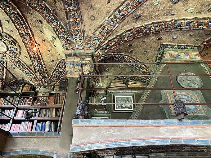 Columns adorned with colorful tiles support vaulted ceilings while sunlight creates geometric patterns on the floor. Architecture as immersive theater.