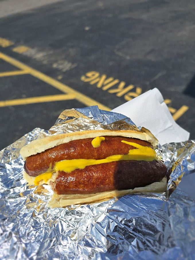 Two sausage links cradled in a soft roll with mustard&mdash;proof that sometimes the simplest pleasures deliver the most profound satisfaction.