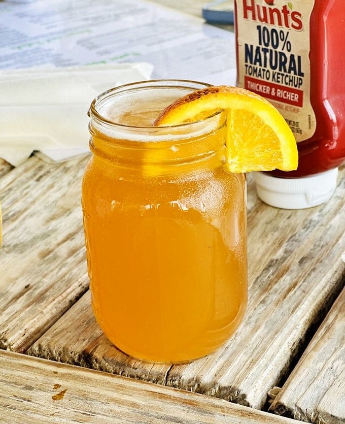 Sweet tea served in a mason jar with an orange slice &ndash; the unofficial champagne of the South and perfect companion to seafood.