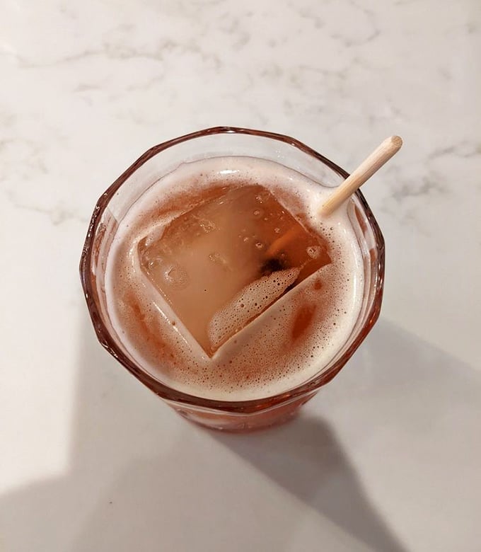 This isn't just a drink &ndash; it's a rosy-hued promise in a glass, complete with that satisfying ice cube that makes everything taste better.