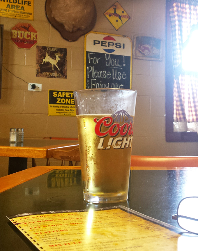 A cold beer in a proper glass with hunting memorabilia in the background&mdash;because after tracking down great barbecue, you deserve to celebrate the victory.