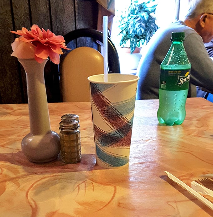 Table settings at Mama's are refreshingly straightforward: paper cups, salt shaker, and a tiny flower vase. No pretension, just the essentials for serious eating.