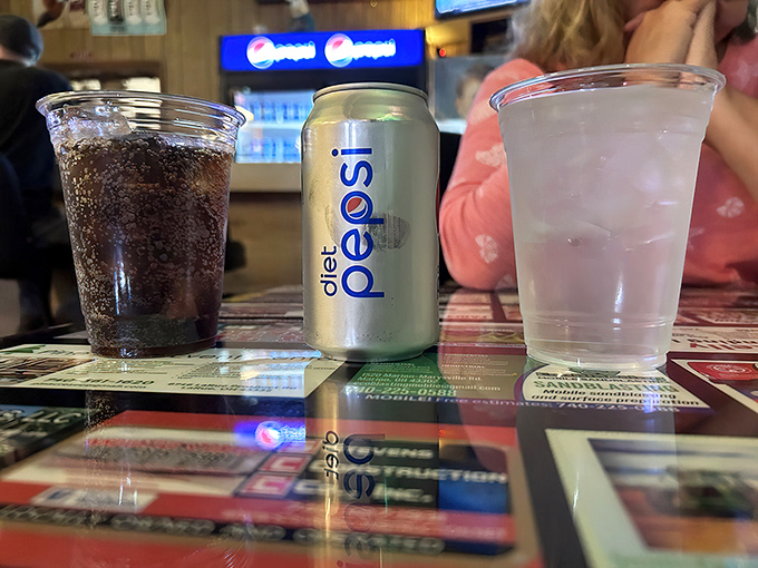 Simple pleasures: ice-cold soda in plastic cups on a classic American diner table. Sometimes the drink is just the supporting actor.