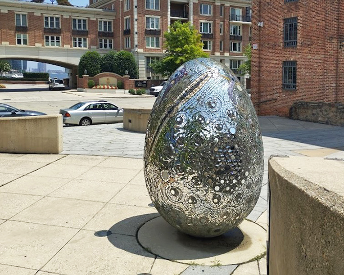 Andrew Logan's mirrored egg sculpture reflects fragments of Baltimore and yourself, a cosmic Easter egg hiding in plain sight.