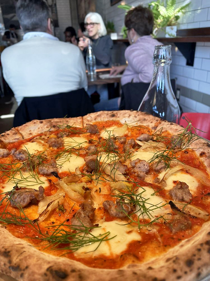 Sausage, fennel, and fresh herbs dance across a perfectly charred crust. It's the pizza equivalent of a perfectly tailored Italian suit &ndash; effortlessly sophisticated.