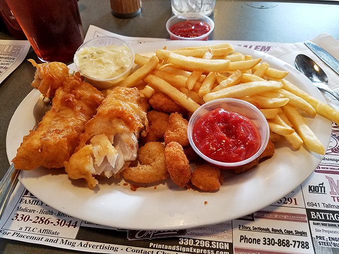 The fish and shrimp platter arrives like a golden fleet on a sea of fries, with tartar sauce islands waiting to be discovered.
