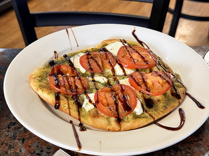 The flatbread arrives like an edible postcard from Italy&mdash;fresh mozzarella melting into pesto with tomatoes that taste like they were picked this morning.