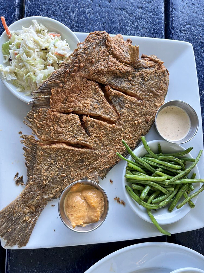This whole fried flounder isn't just a meal, it's a conversation piece&mdash;crispy, golden, and ready for its Instagram moment with green beans standing by.