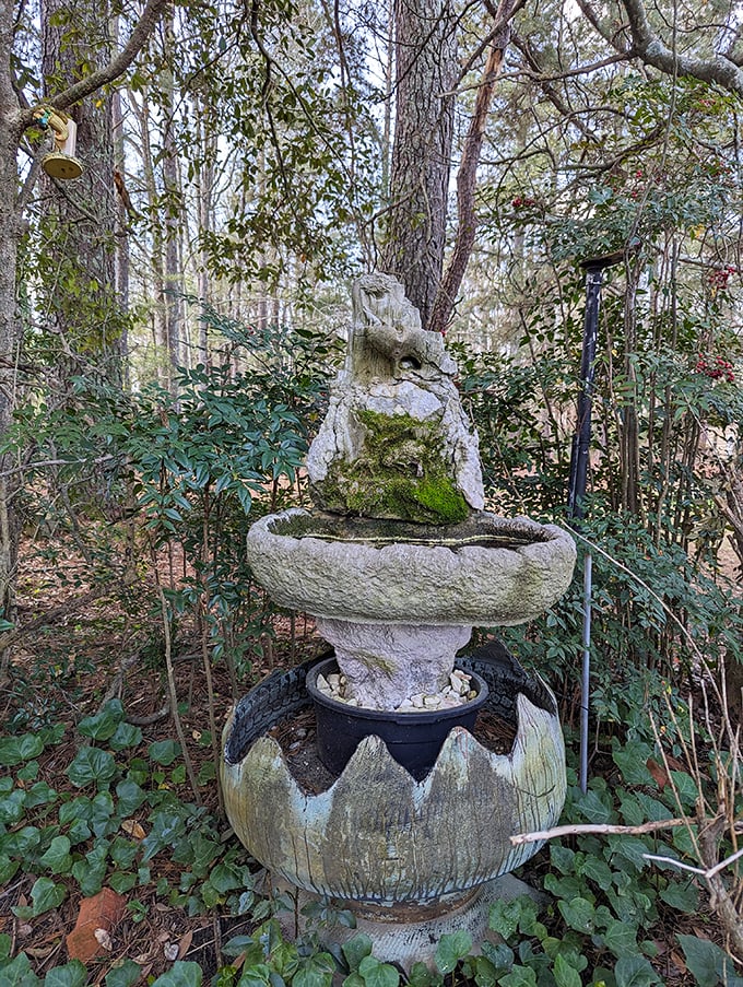 A moss-kissed fountain nestled among the greenery offers a moment of tranquil reflection. Even the water features here have artistic personality.