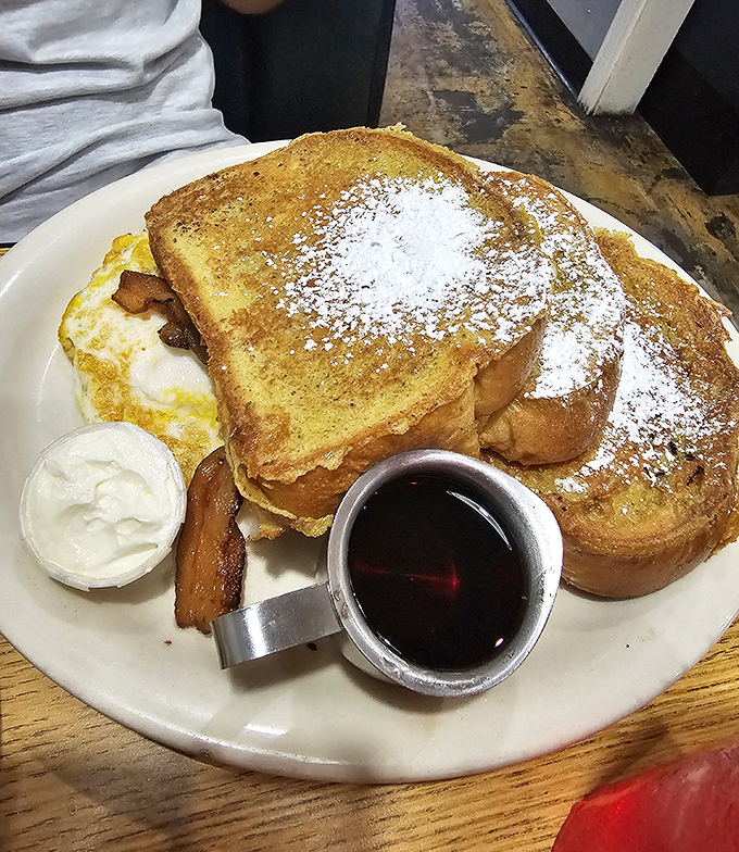 French toast that's achieved the impossible balance &ndash; crisp exterior giving way to custardy interior, with powdered sugar falling like delicious snow.