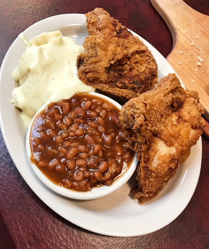 Fried chicken with the golden ratio of crispy coating to juicy meat, flanked by baked beans that didn't come from any can.