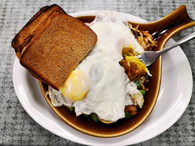 Breakfast architecture at its finest&mdash;eggs perched atop a foundation of toast with crispy hash browns playing a supporting role.