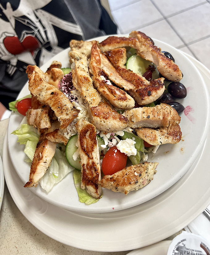 A Greek salad that actually delivers on its Mediterranean promises. Grilled chicken with perfect char marks atop a garden of freshness.