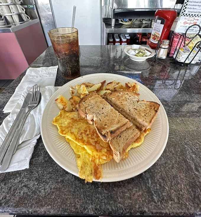 Breakfast perfection on a plate&mdash;golden omelet, crispy home fries, and toast standing by for important yolk-sopping duties. This is why morning people exist.