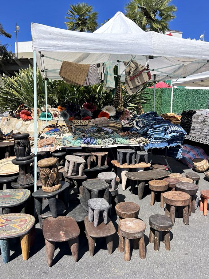 An army of hand-carved wooden stools stands at attention, each one looking like it belongs in either a rustic mountain cabin or a high-end design magazine.