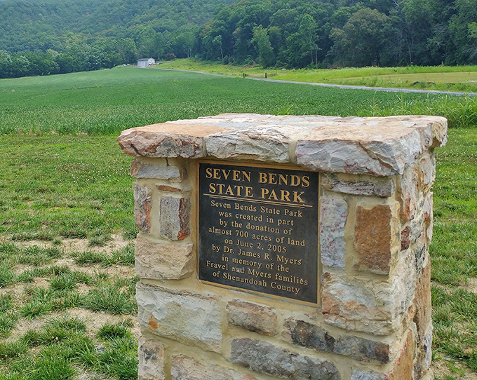 History carved in stone: a humble marker that reminds us this paradise exists because someone loved this land enough to share it.