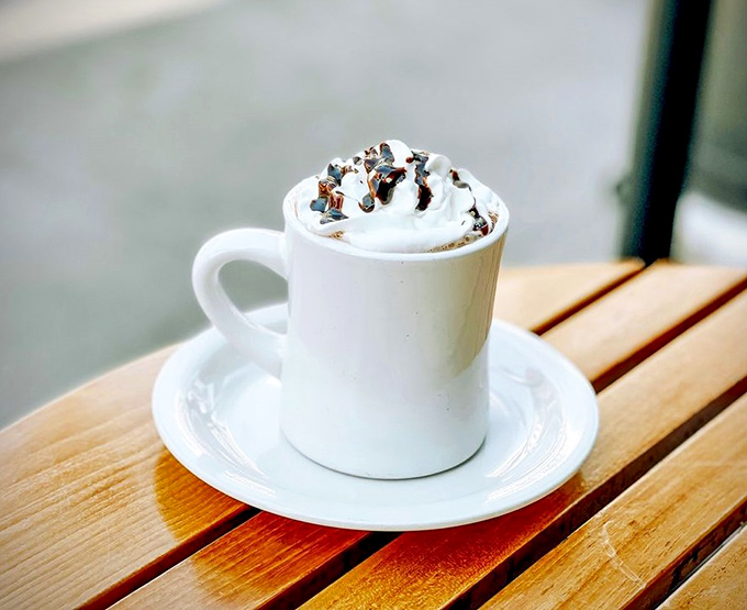 Hot chocolate topped with whipped cream and chocolate bits&mdash;because sometimes adulting means having dessert in a mug before noon.