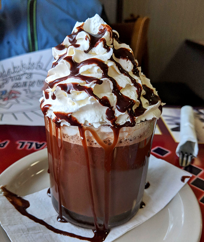 This hot chocolate isn't just a beverage &ndash; it's a towering monument to whipped cream and chocolate drizzle decadence.