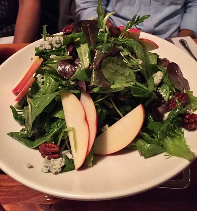 The house salad offers a refreshing counterpoint to pizza indulgence&mdash;crisp greens, seasonal fruit, and a vinaigrette that means business.