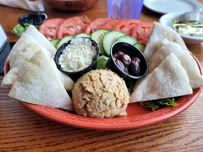 Mediterranean vacation on a coral plate&mdash;hummus, pita, olives, and fresh veggies create a colorful oasis in the heart of South Dakota.