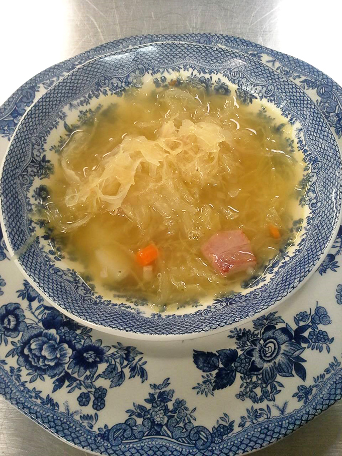 This traditional kapuśniak soup, swimming with sauerkraut and bits of ham, is like a warm hug from the inside out. Comfort in a blue-rimmed bowl.