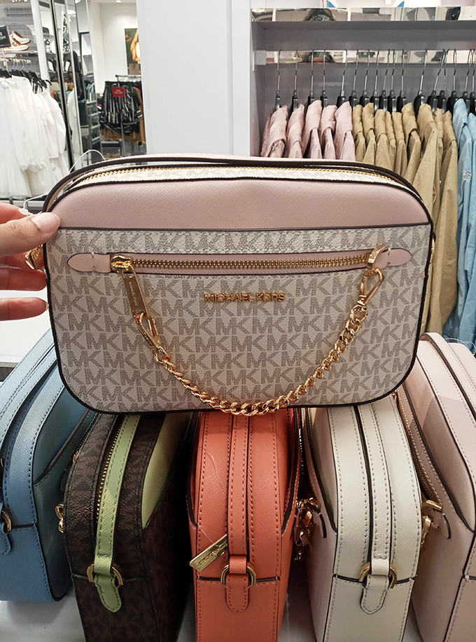 Michael Kors handbags lined up like soldiers ready for duty. Your arm's new best friend awaits among these pastel treasures.