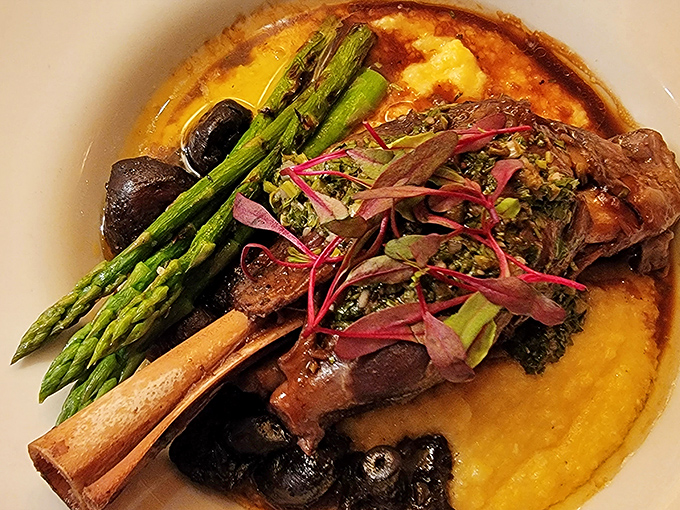 Lamb shank resting on polenta like royalty on a throne. The meat practically waves goodbye to the bone as your fork approaches.