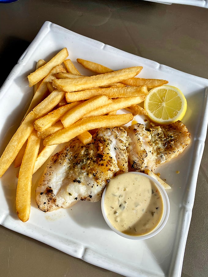 Simple perfection on a plate: delicately seasoned fish, golden fries, and a herb-flecked sauce that whispers rather than shouts.