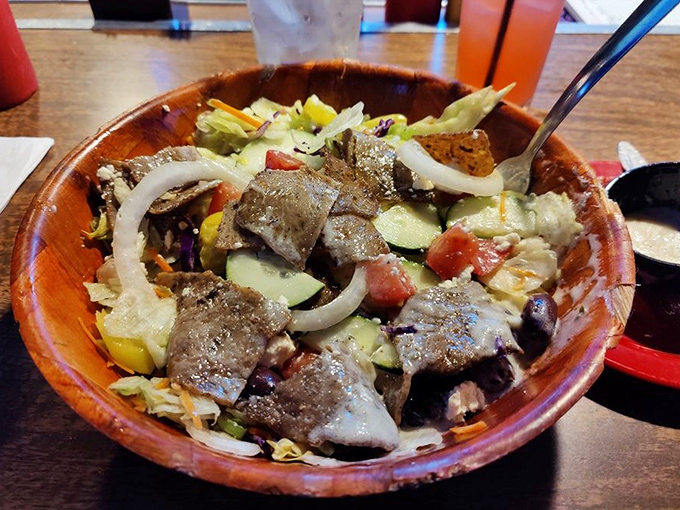 A wooden bowl cradles this hearty salad&mdash;the token vegetable option that somehow still feels indulgent. Guilt, meet pleasure.