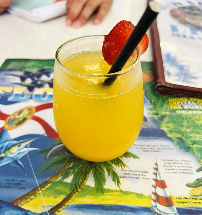 A sunshine-yellow mimosa garnished with fresh strawberry&mdash;because nothing says "vacation in Miami" quite like brunch cocktails under palm trees.