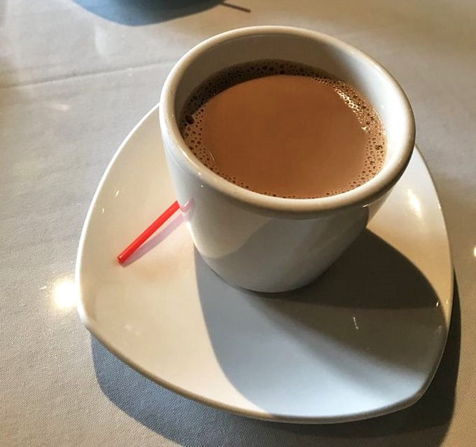 Masala chai served with respect—no oversized mug, just the perfect portion of spiced comfort. This isn't a beverage; it's liquid meditation.