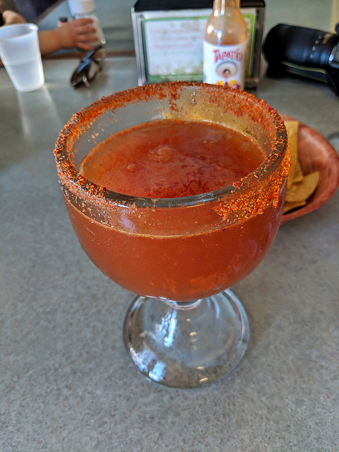 The michelada arrives like a spicy sunset in a glass, with a chili-salt rim that's both warning and invitation.