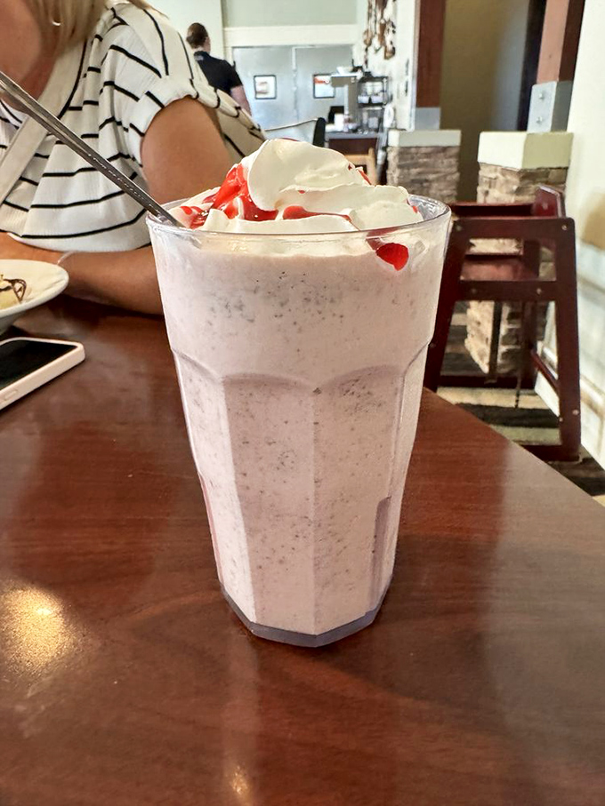 This isn't just a milkshake; it's dessert architecture topped with whipped cream and cherries that demands to be photographed before consumed.